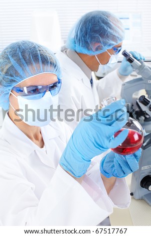 Science team working with microscopes in a laboratory - Stock Image - Everypixel