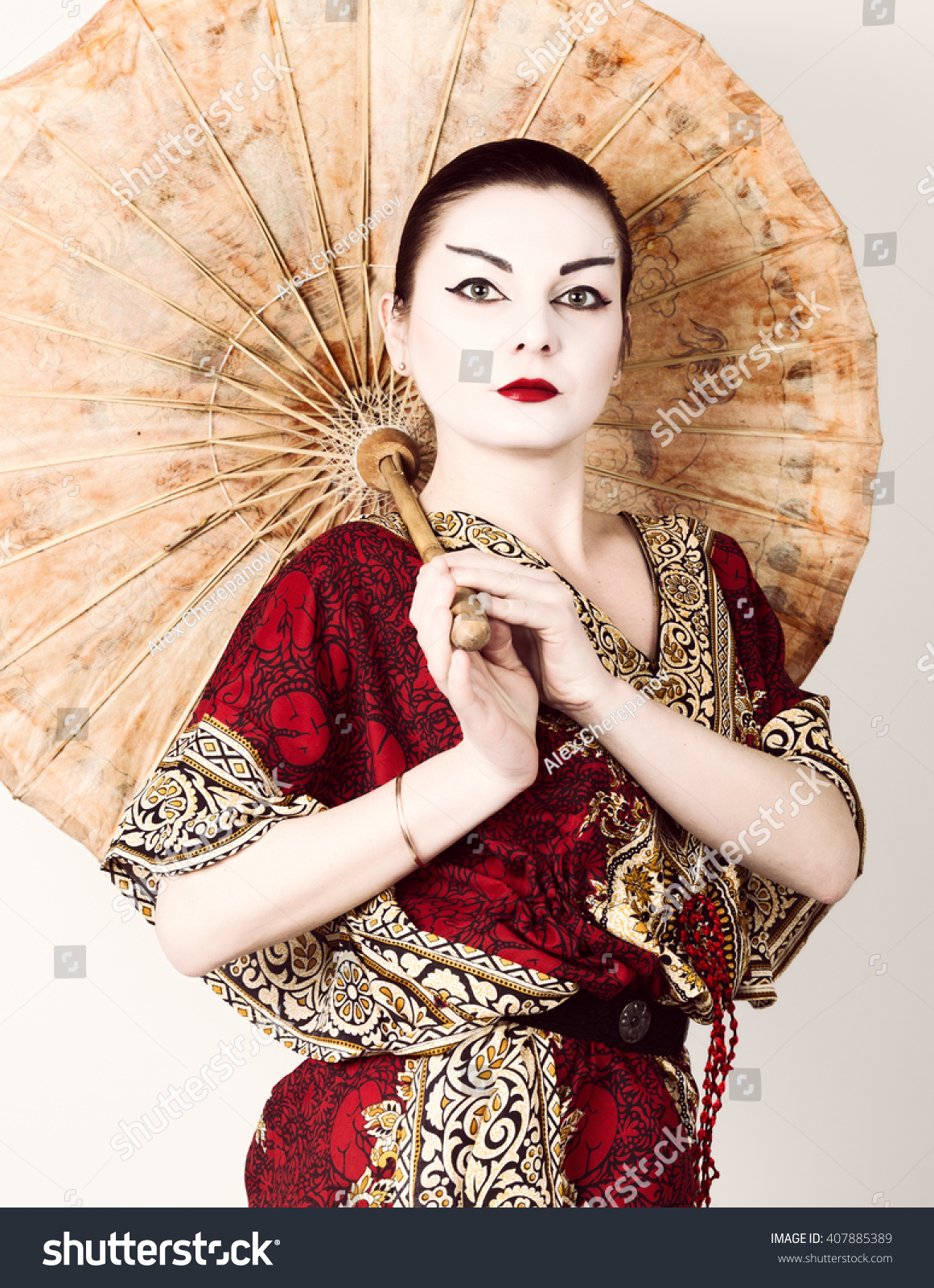 Beautiful Girl Dressed As A Geisha Girl Holding A Chinese Umbrella