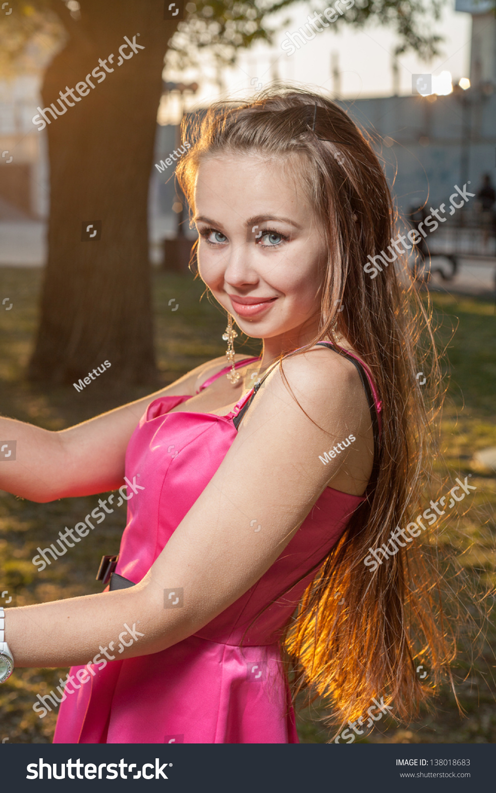 Beautiful Woman Pink Dress In A Park Outdoor Backlit By Sunlight Near