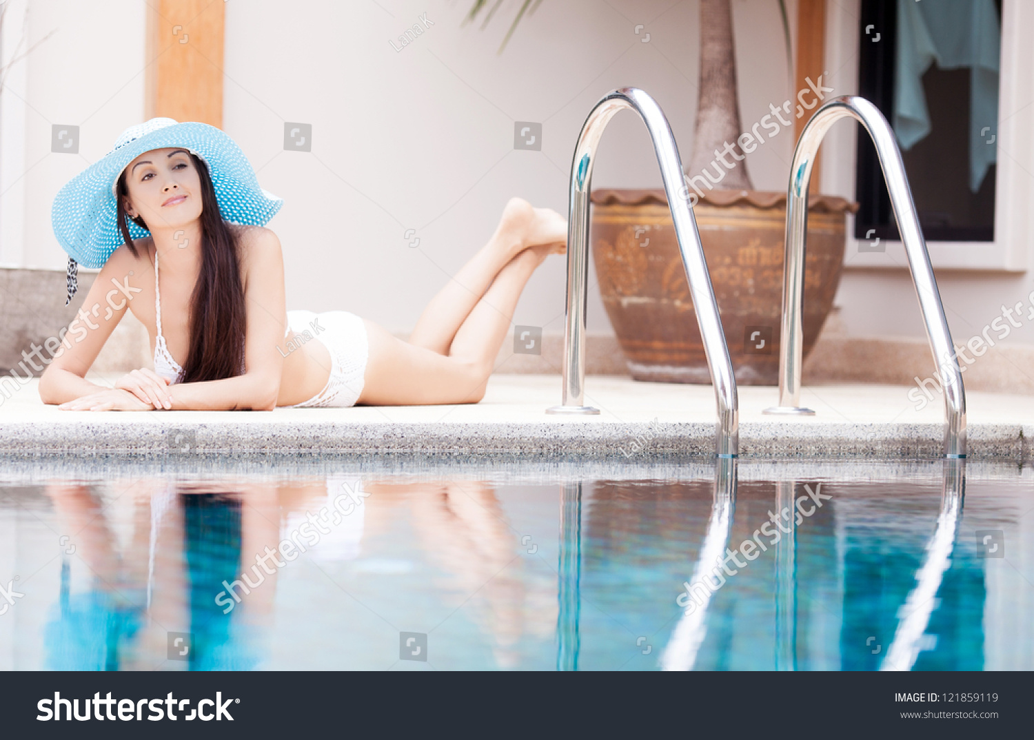 Beautiful Young Brunette Woman Relaxing By The Swimming Pool Stock