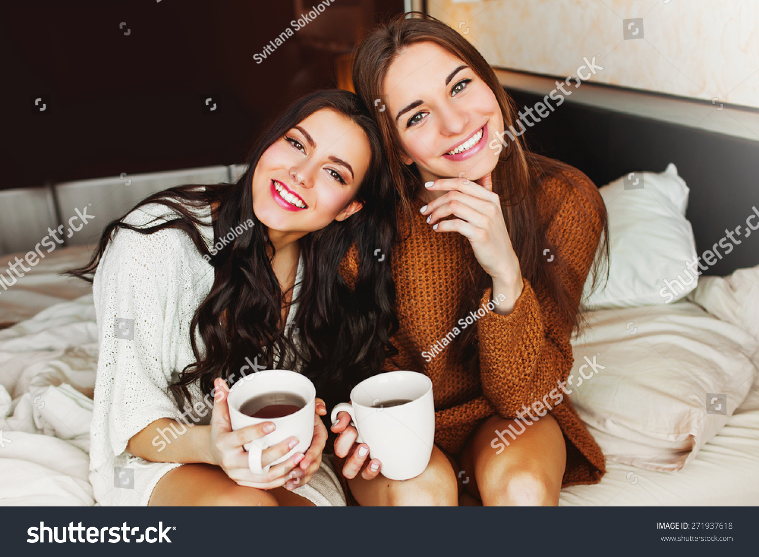 Close Up Indoor Lifestyle Portrait Of Two Pretty Cheerful Girls Holds
