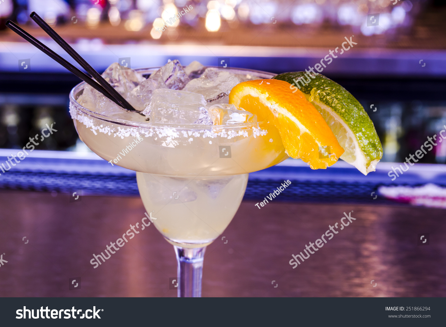 Close Up Of Fresh Lime Margarita With Ice Cubes In Margarita Glass Sitting On Bar Top Garnished