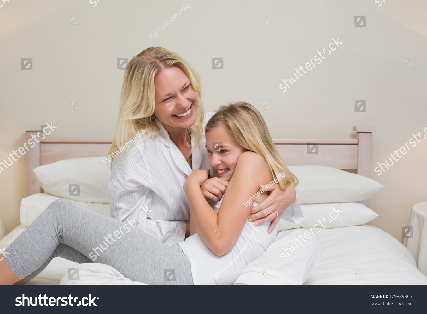 Happy Woman Tickling Daughter In Bed At Home Foto Darchivio 179889365