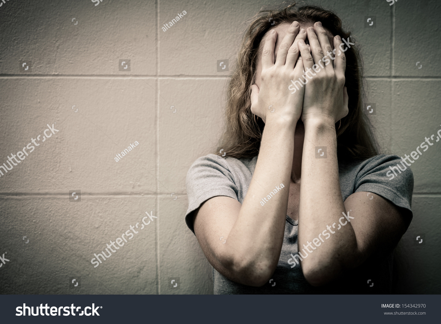 One Sad Woman Sitting On The Floor Near A Wall And Holding Her Head In