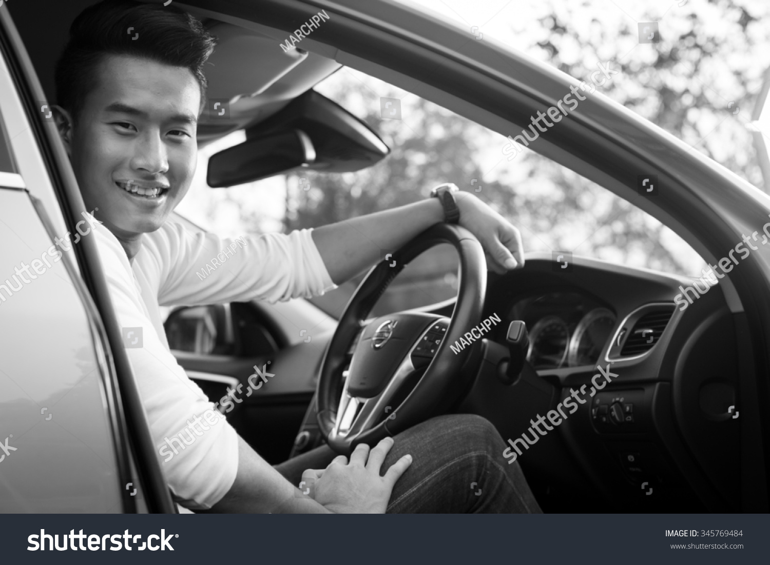 Portrait Of An Handsome Smiling Asian Business Man Driving His Car With