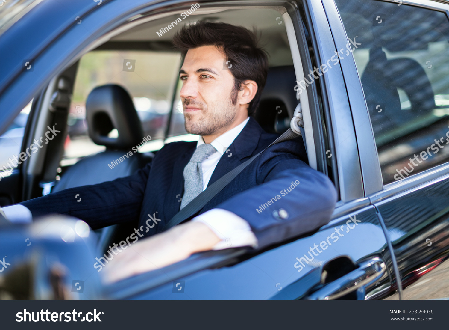 Portrait Of An Handsome Smiling Business Man Driving His Car Stock
