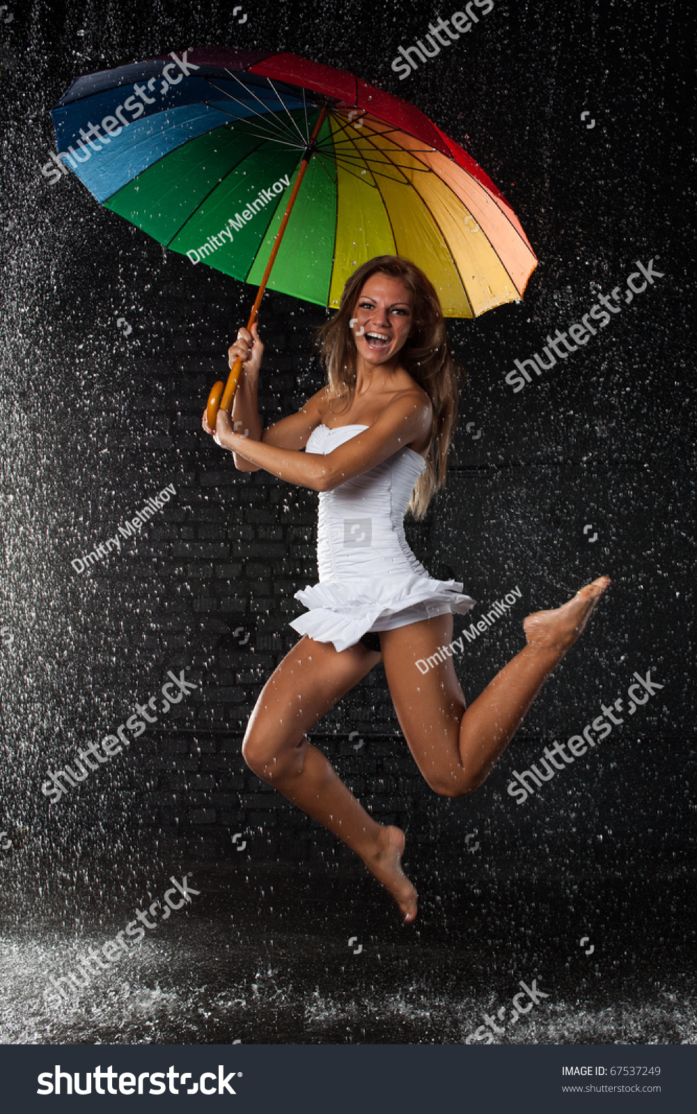 Young Pretty Woman With Multi Coloured Umbrella Under Rain On A Black
