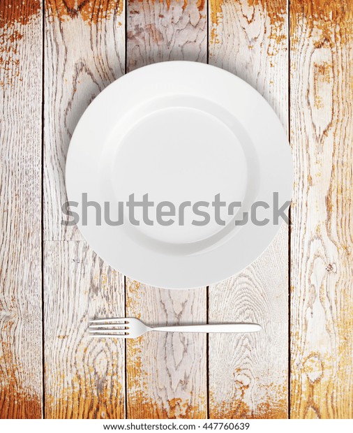 Top view of empty plate and fork on aged wooden table. Mock up, 3D ...