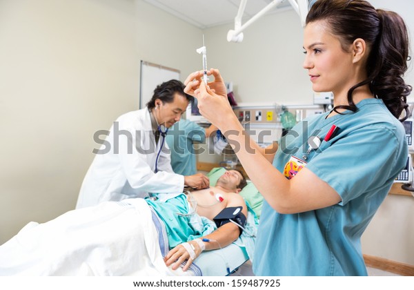 Beautiful Nurse Preparing Injection While Doctor Foto stock 159487925 ...