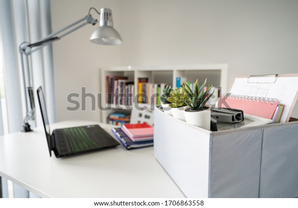 Box mit persönlichen Sachen, die auf dem weißen Tisch im Büro oder zu ...