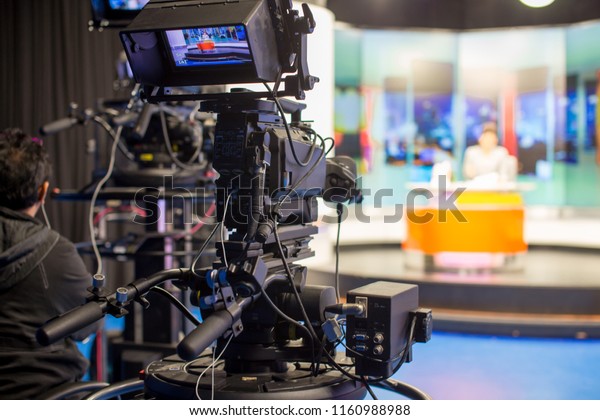 Camera in studio are broadcasting journalists reading news.Blur ...