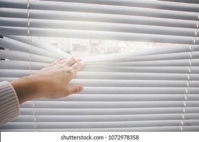 Person Looking Through Window Shutters Stock Photo (Edit Now) 395534359
