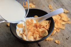 Corn Flakes cereal with milk in a bowl and cap with espresso coffee ...