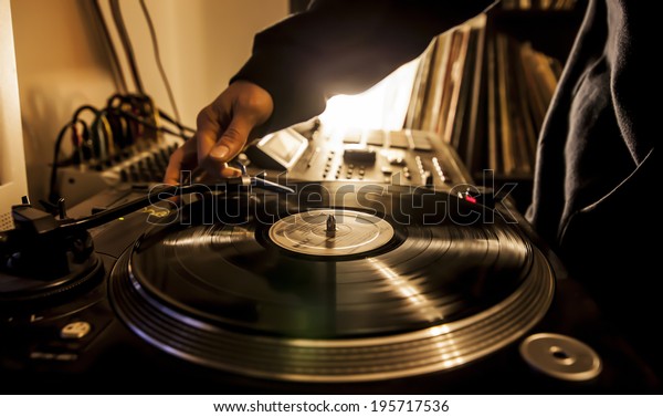 Dj in studio puts needle on record