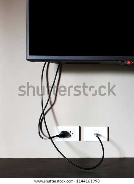 An electrical socket and TV outlet in the drywall in the room of in ...