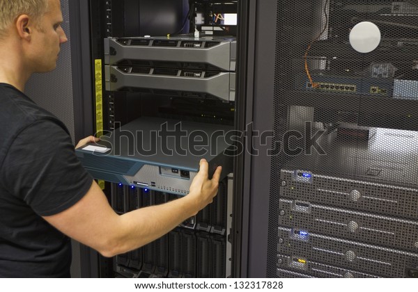 Ingeniero / consultor instalar / inserta un router / switch en un rack ...