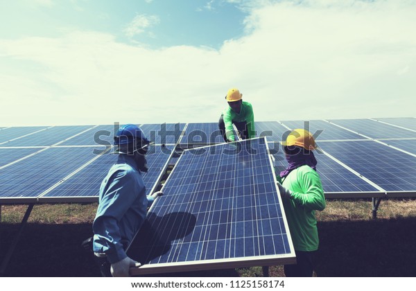 engineer team working on replacement solar panel in solar power plant ...