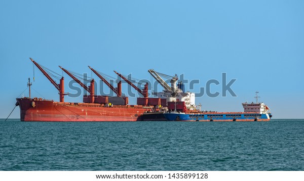 Floating Crane Transhippers in the process of loading Bauxite aluminum ...