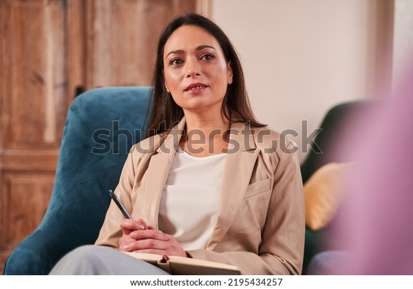 Friendly Therapist Making Notes Looking Her Stock Photo 2195434257 ...