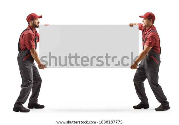 Full length shot of two male workers carrying a blank panel board ... Full length shot of two male workers carrying a blank panel board ...