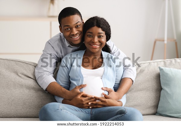 Happy Expecting African American Couple Cuddling While Spending Time