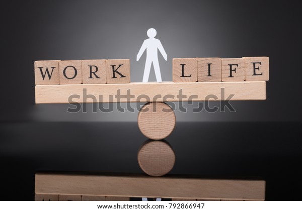 Human Figure Balancing Between Work And Life On Wooden Seesaw Against ...