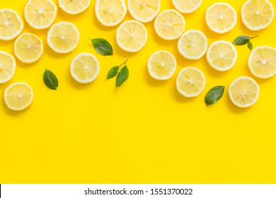 Tomat kuning dan lemon potong dalam gelas dengan latar belakang kuning ...