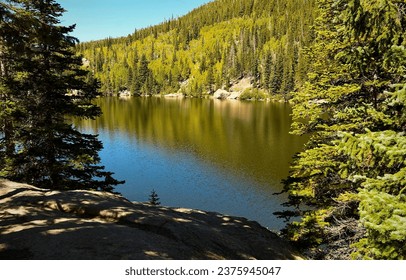 Waterfall flowing into the lake and mossy stones on the rocks in the ...