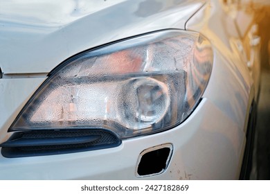 BMW negro con faros encendidos en garaje 2K descarga de fondo de pantalla