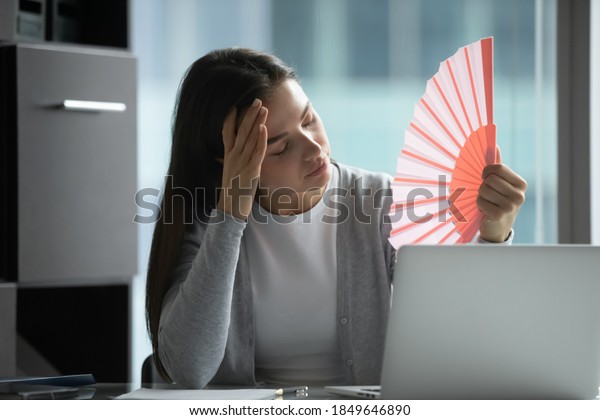 Impossible to work without air conditioner! Unhappy sad young female ...