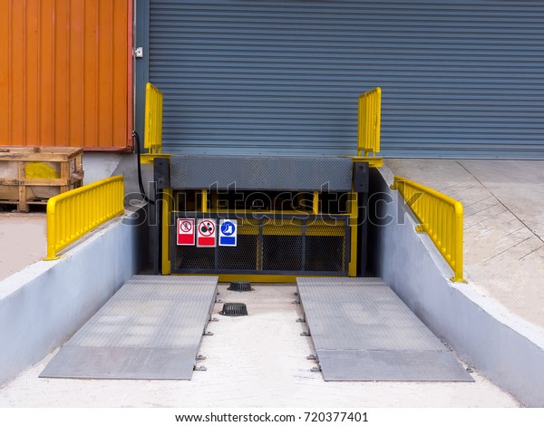 Loading dock leveler ramp outside warehouse building for loading and ...