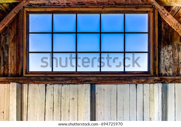 Looking through old rustic window of house with ocean view in ...