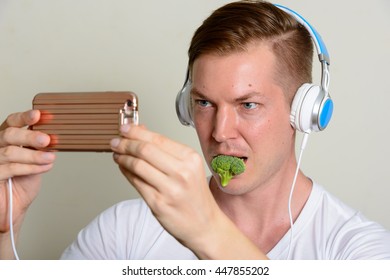 Man Eating Broccoli While Using Mobile Stock Photo 447855202 | Shutterstock