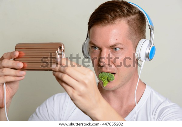 Man Eating Broccoli While Using Mobile Stock Photo 447855202 | Shutterstock