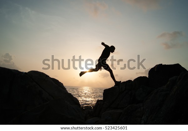 Man Jump Through Gap Between Hill Stock Photo (Edit Now) 523425601
