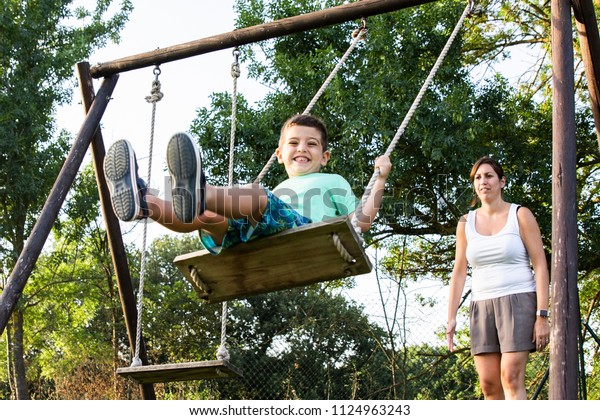 Mother Swinging Her Son On Swing foto stock 1124963243 | Shutterstock