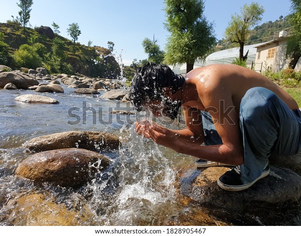 Photo Of A Shirtless Man Washing Face In River Indian Guy Washing Face
