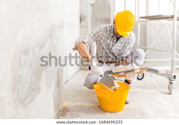 Стоковая фотография 1684696333: Plasterer Loading New Plaster Bucket ...