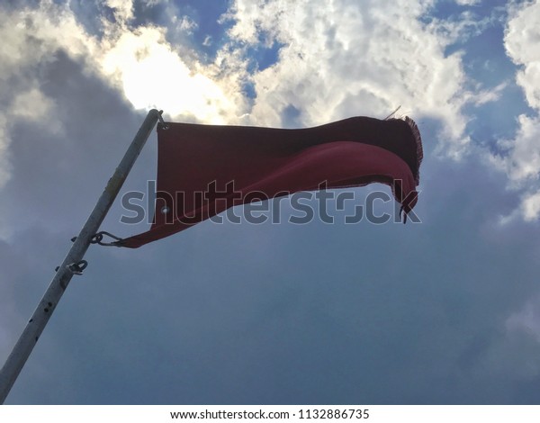 Red Flag Flying Storm Clouds Behind Stock Photo (Edit Now) 1132886735
