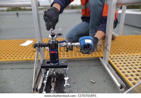 Rope access engineer conducting using pull machinery testing chemical ...