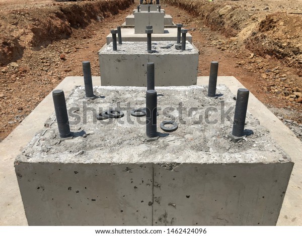 Fila de cimientos de hormigón armado con tornillos de anclaje metálico ... Fila de cimientos de hormigón armado con tornillos de anclaje metálico ...