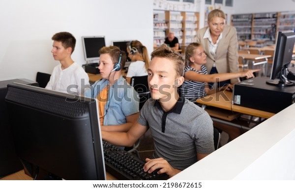 Schoolchildren Using Computers Teacher Teaching Them Stock Photo ...