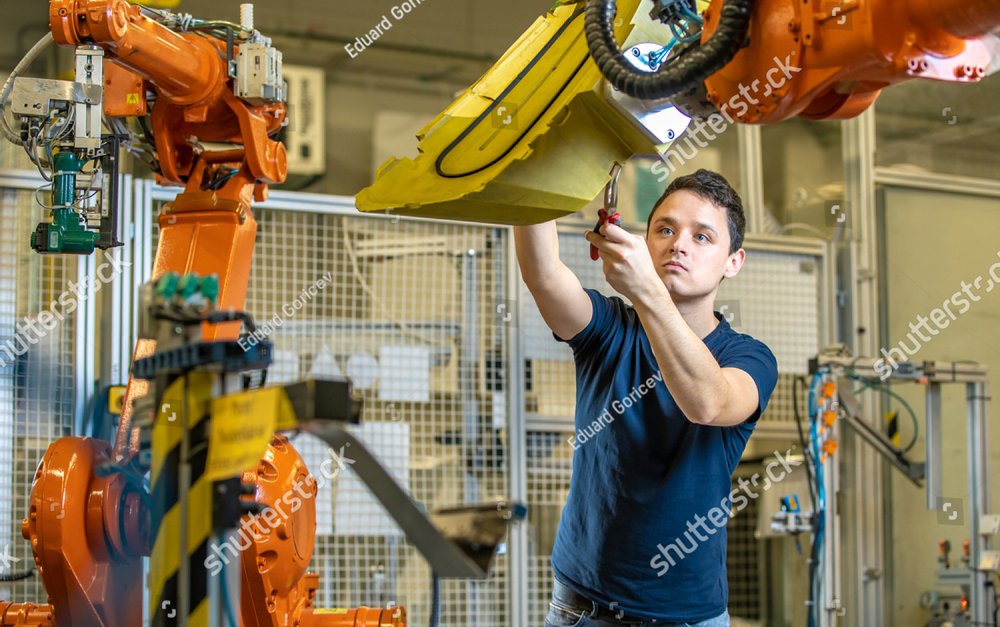 setting up a robotic line with automatic arms before starting the ...