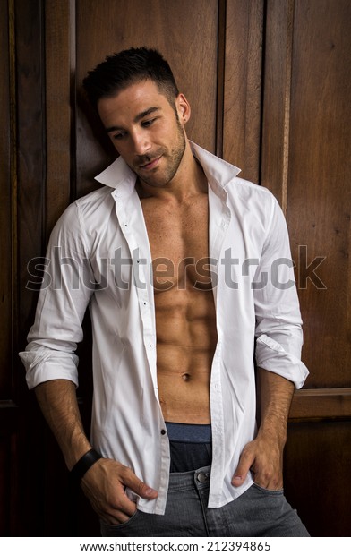 Sexy handsome young man standing in white open shirt with a smile in ... Sexy handsome young man standing in white open shirt with a smile in ...