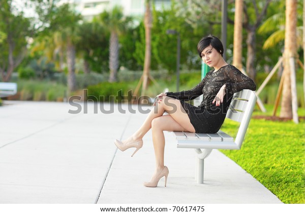 Sexy Woman Sitting On A Park Bench