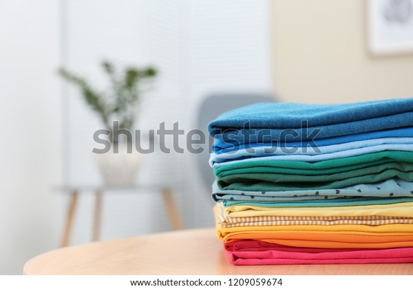 Stack Bright Folded Clothes On Table Stock Photo (Edit Now) 1209059674