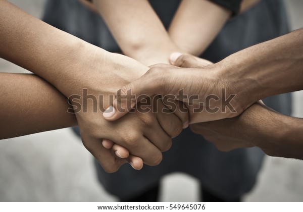 Three human hands join together.