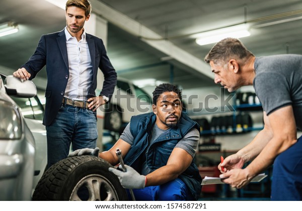 Two Auto Mechanics Cooperating While Repairing Stock Photo 1574587291 ...