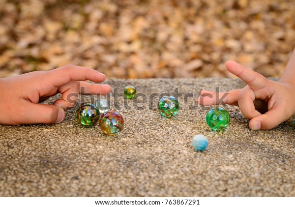 Dos niños jugando a las canicas