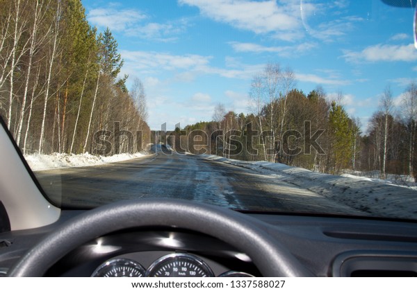 View of the road through the windshield. Spring forest. Wet road. Blue ...